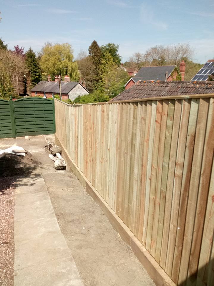 Domestic sleeper retaining wall with close board fencing fitted on top ...